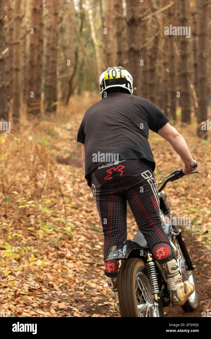 Motorcycle trials rider standing up between sections Stock Photo - Alamy