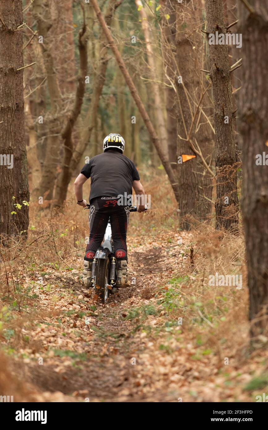 Motorcycle trials rider standing up between sections Stock Photo - Alamy