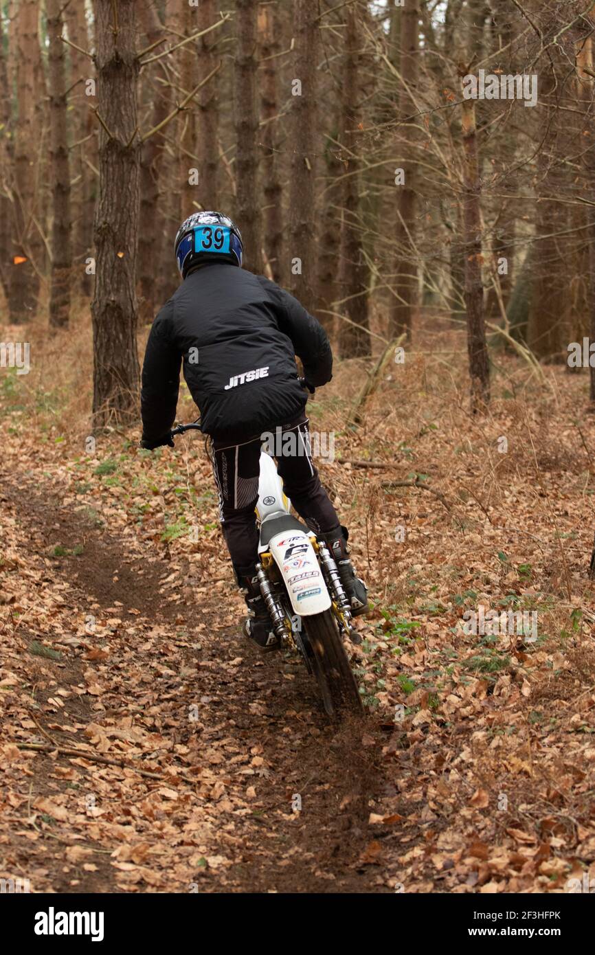 Motorcycle trials rider standing up between sections Stock Photo - Alamy