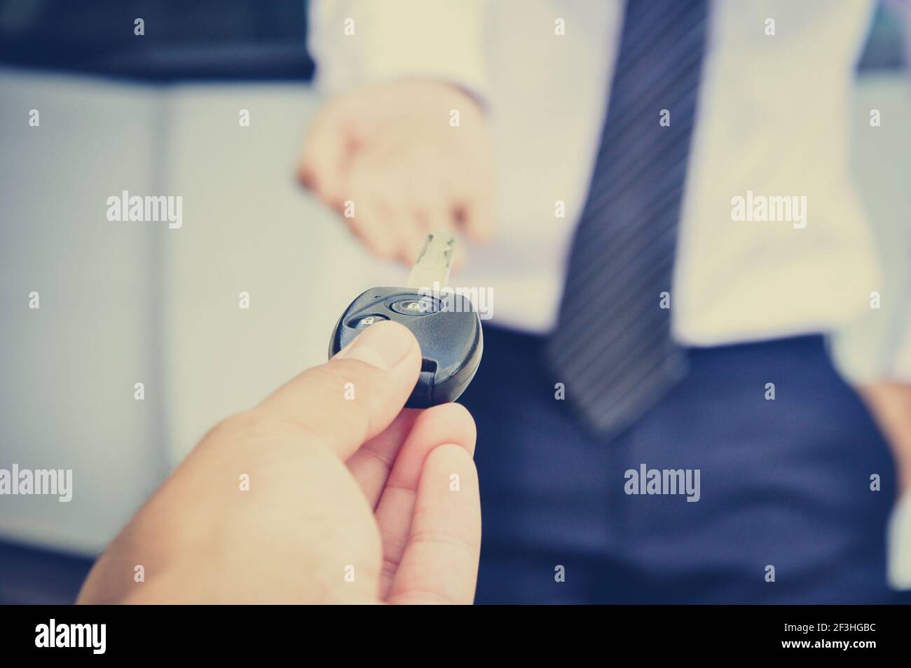 Hand giving car key to a businessman, car sale & rental concepts ...