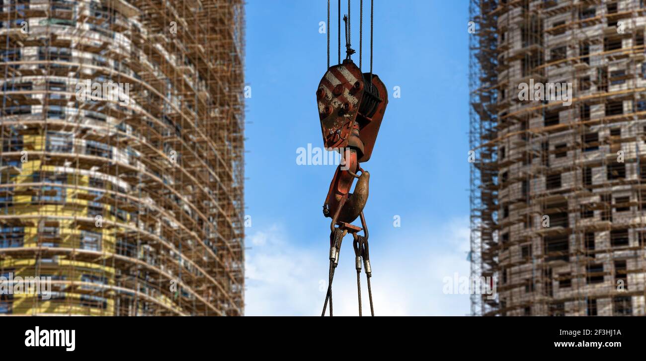 Construction crane hook with multi-storey building under construction ...