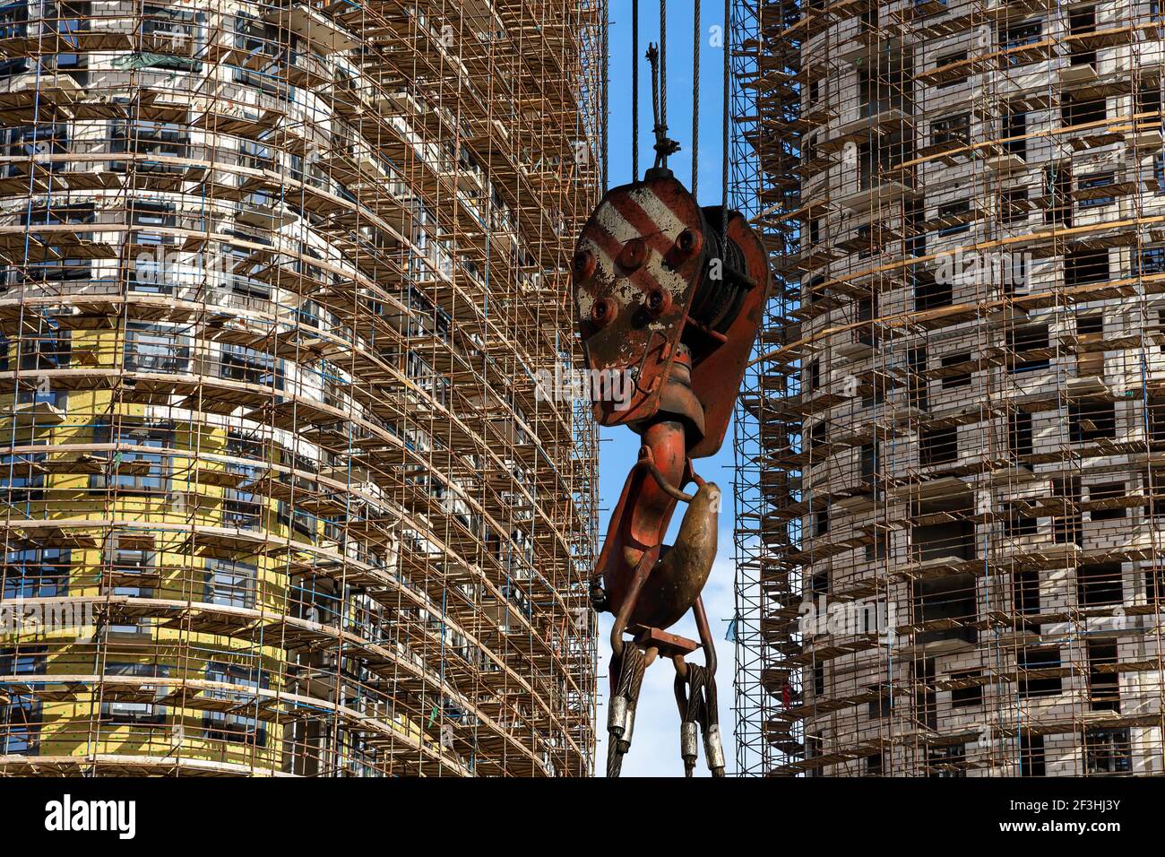 Construction crane hook with multi-storey building under construction ...