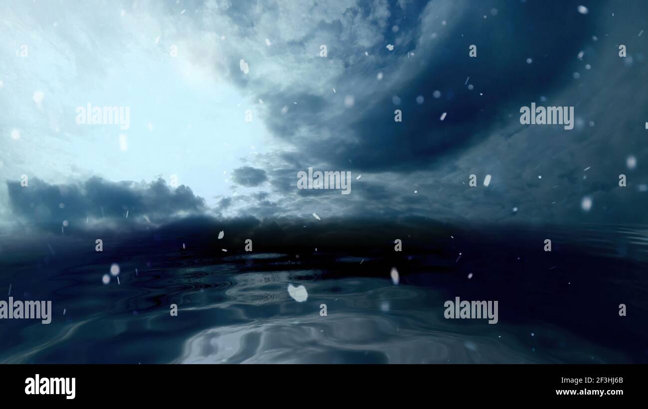 Snowing on Stormy Clouds Over Dark Ocean Stock Photo - Alamy