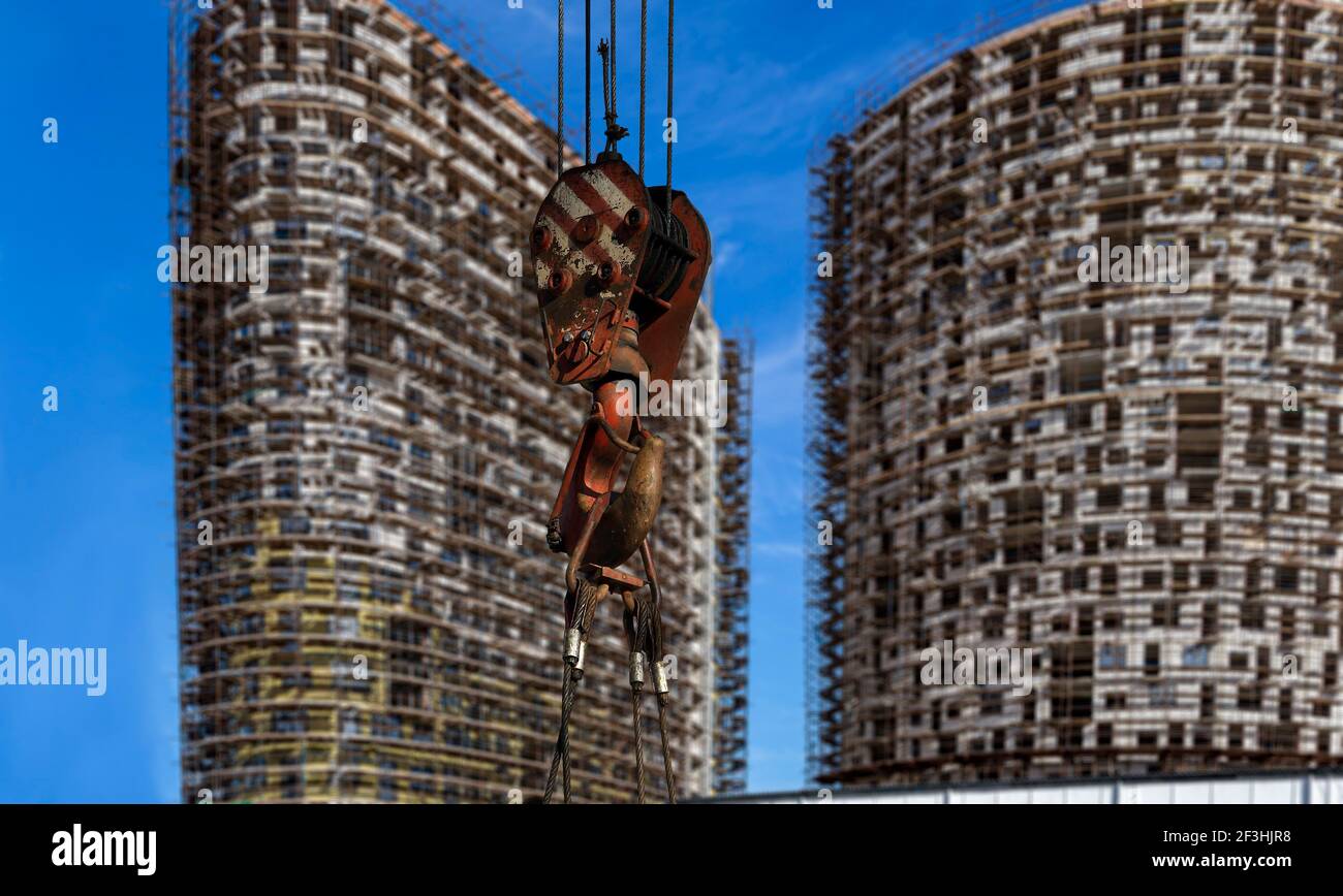 Construction crane hook with multi-storey building under construction ...