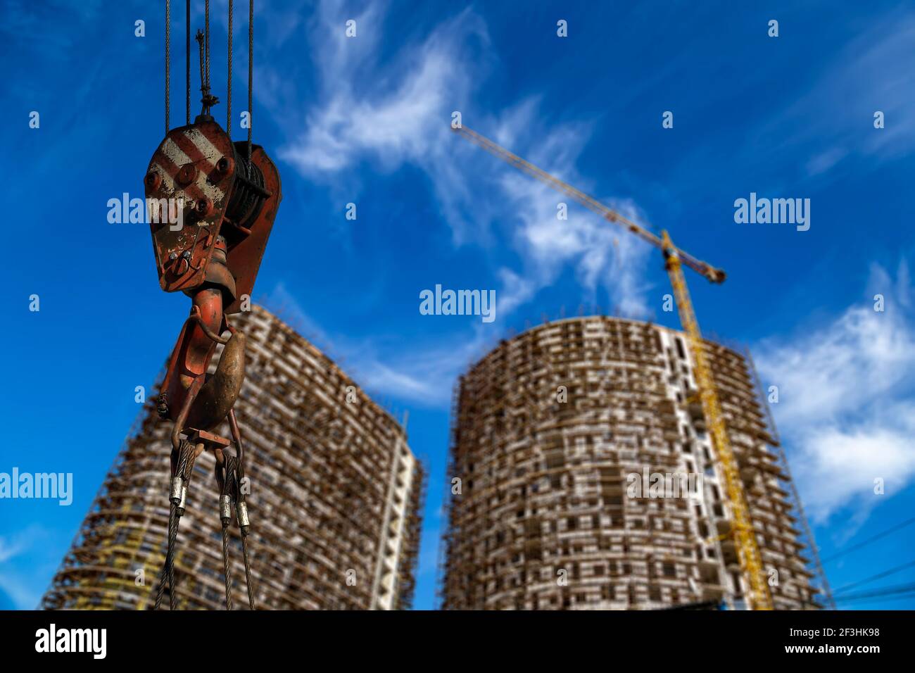 Construction crane hook with multi-storey building under construction ...