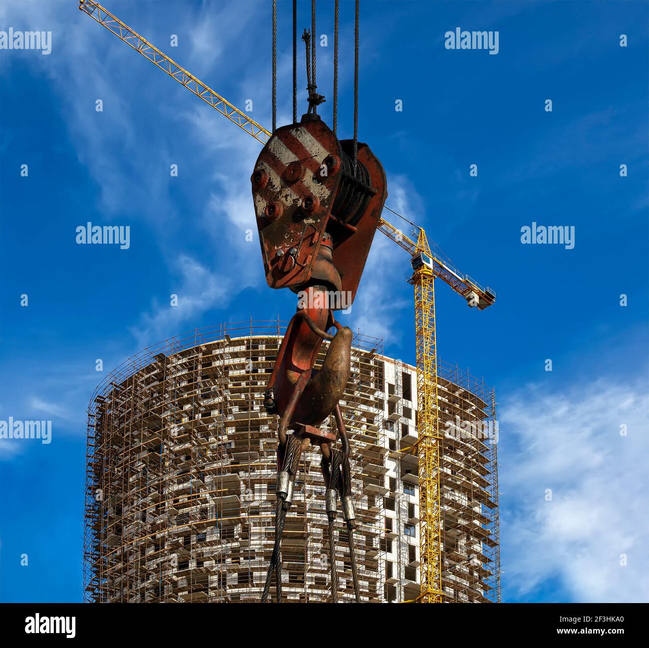 Construction crane hook with multi-storey building under construction ...