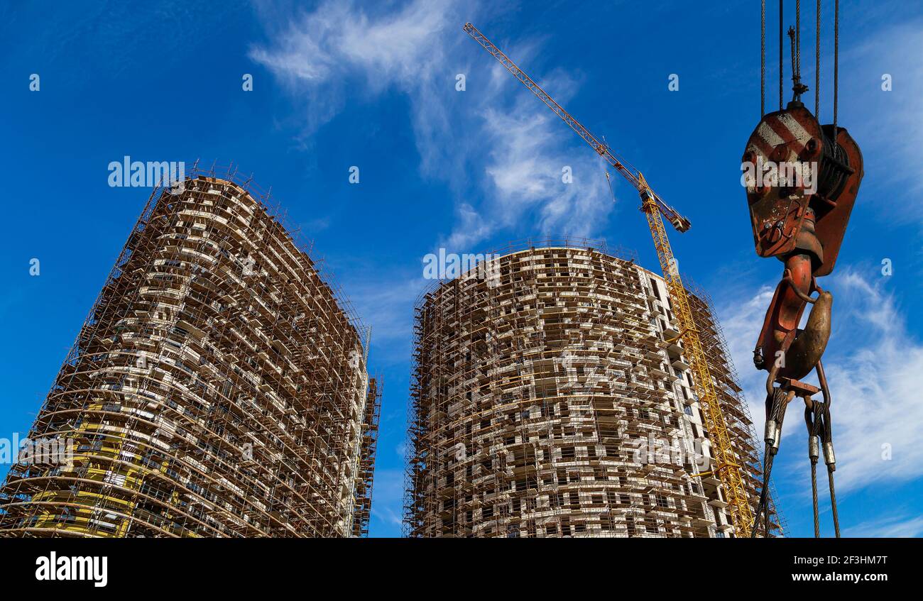 Construction crane hook with multi-storey building under construction ...