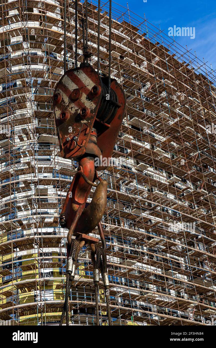 Construction crane hook with multi-storey building under construction ...