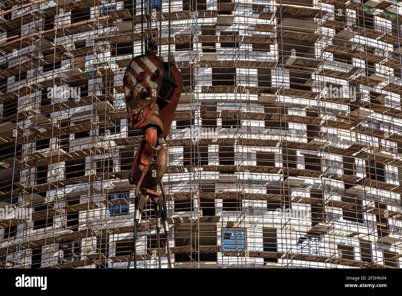 Construction crane hook with multi-storey building under construction ...