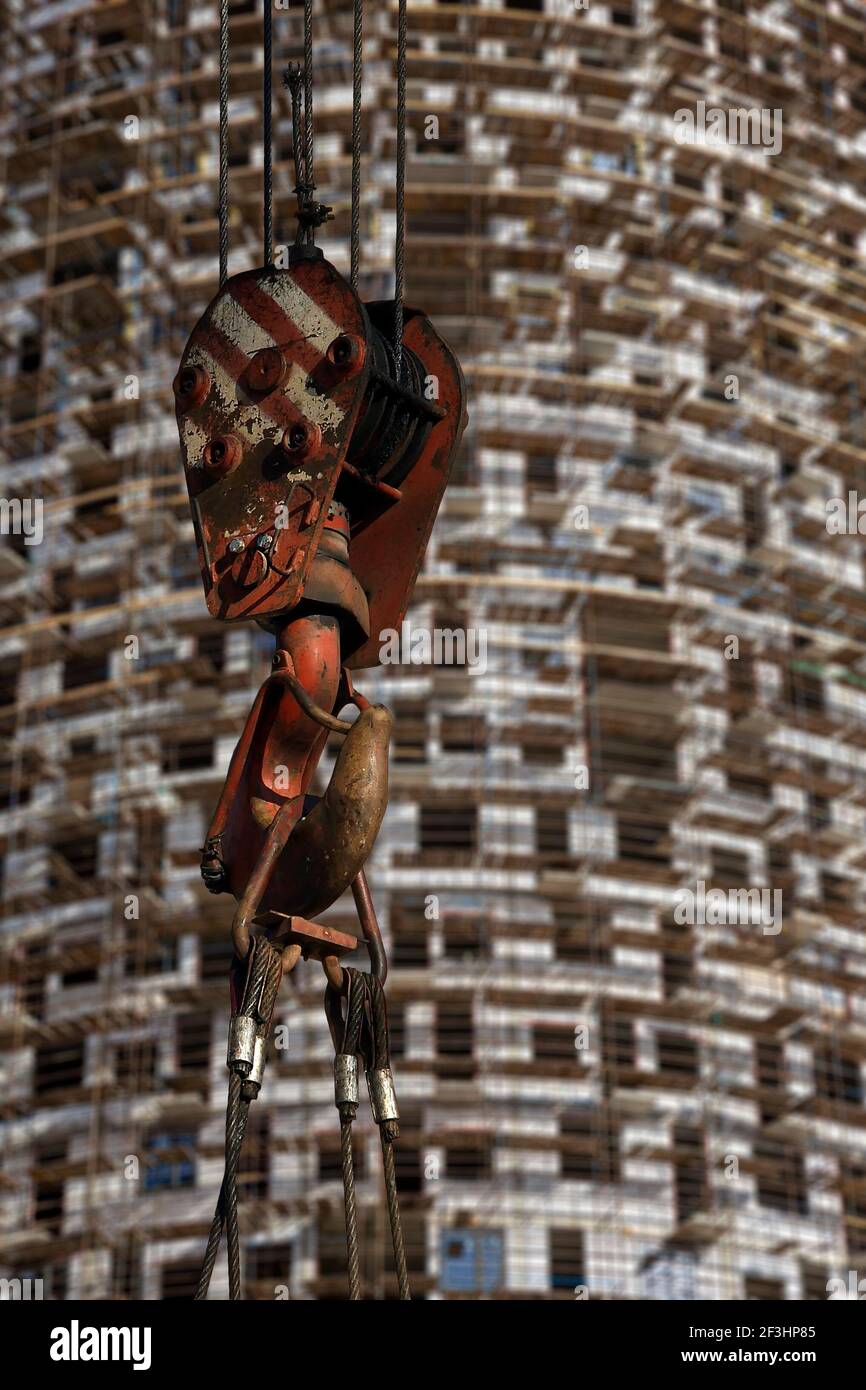 Construction crane hook with multi-storey building under construction ...