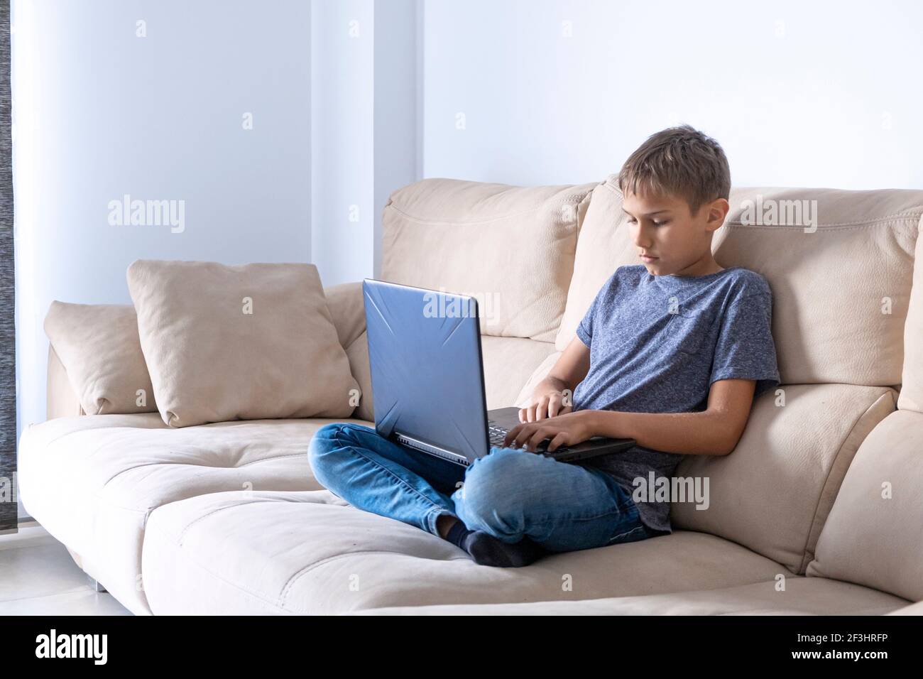 Boy doing homework task with laptop computer, watching video. Online ...