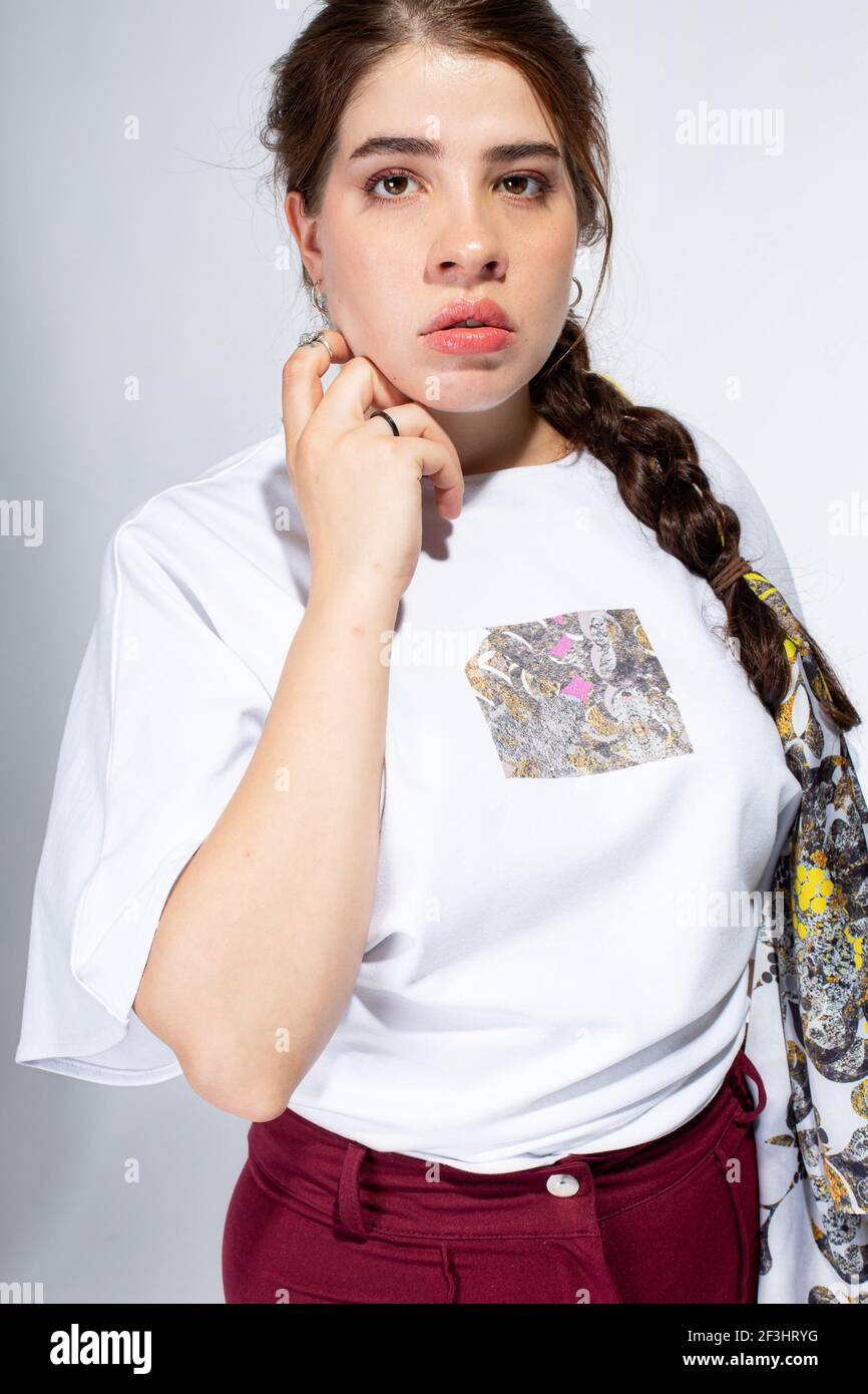 Sad european young girl portrait with hand near the face on light grey ...