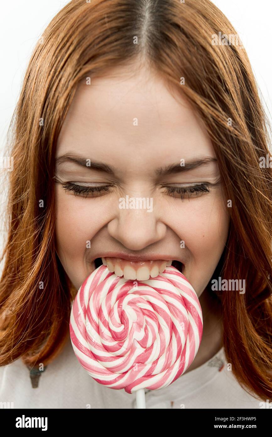 pretty red-haired woman eating lollipop enjoyment emotion close-up ...
