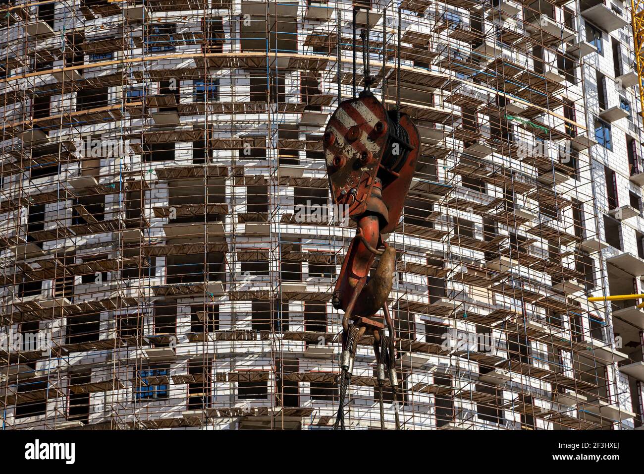 Construction crane hook with multi-storey building under construction ...