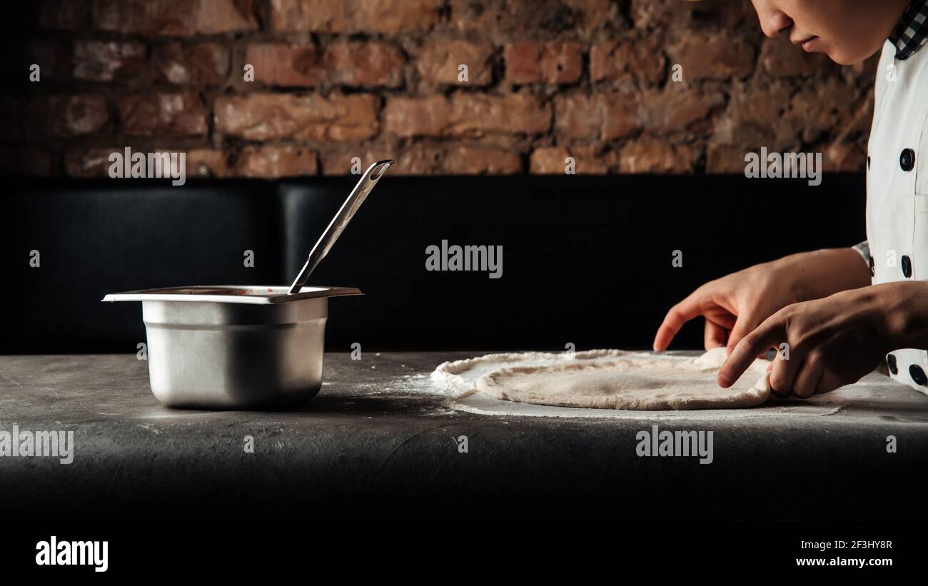 Man making a pizza dough with flour Stock Photo - Alamy