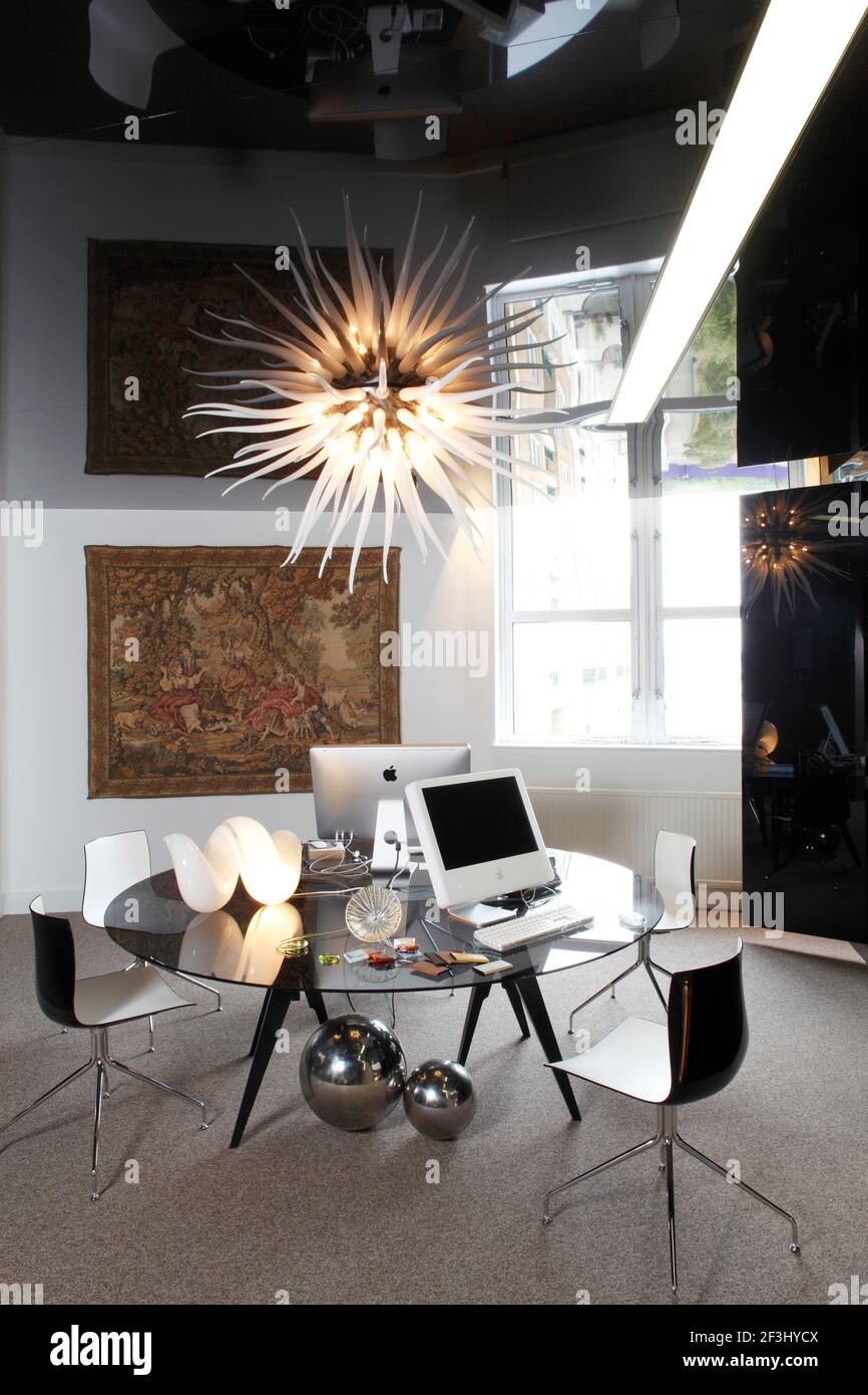 Circular glass desk with computers beneath a contemporary glass ...