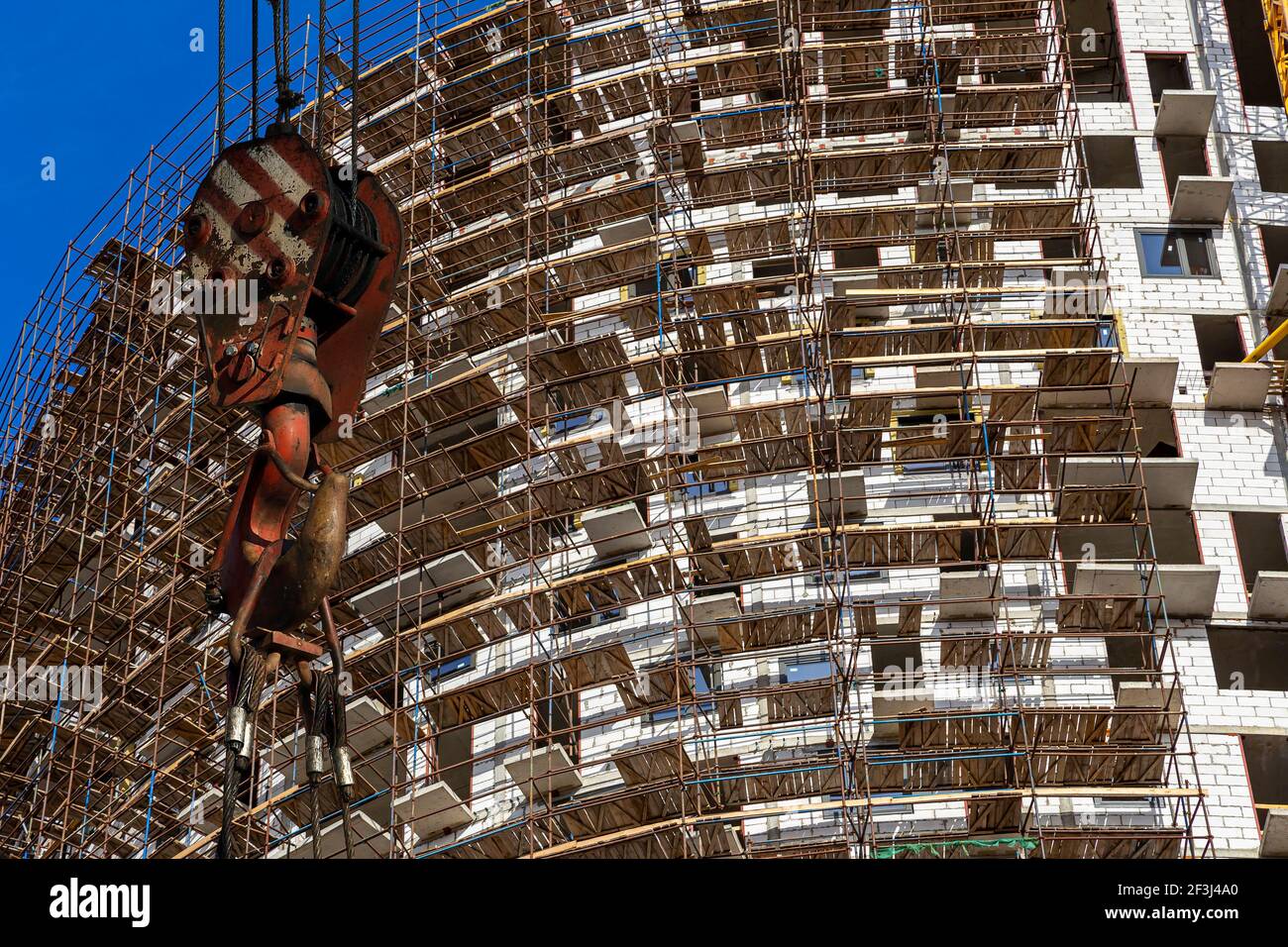 Construction crane hook with multi-storey building under construction ...
