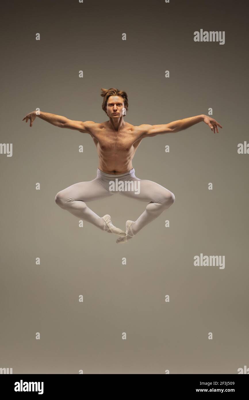 Powerful. Young and graceful ballet dancer isolated on studio ...