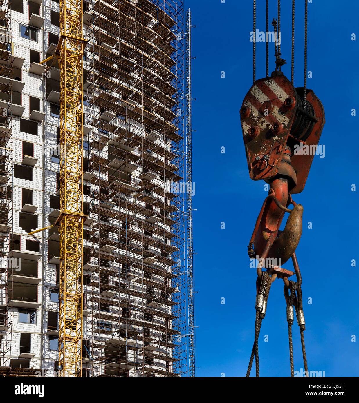 Construction crane hook with multi-storey building under construction ...