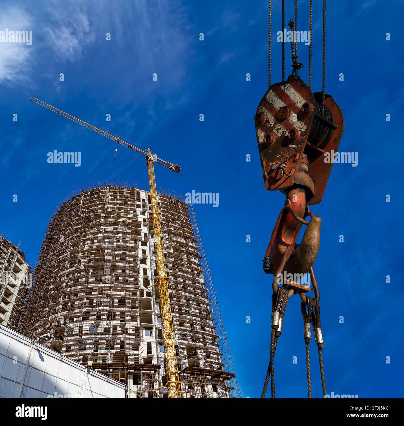 Construction crane hook with multi-storey building under construction ...