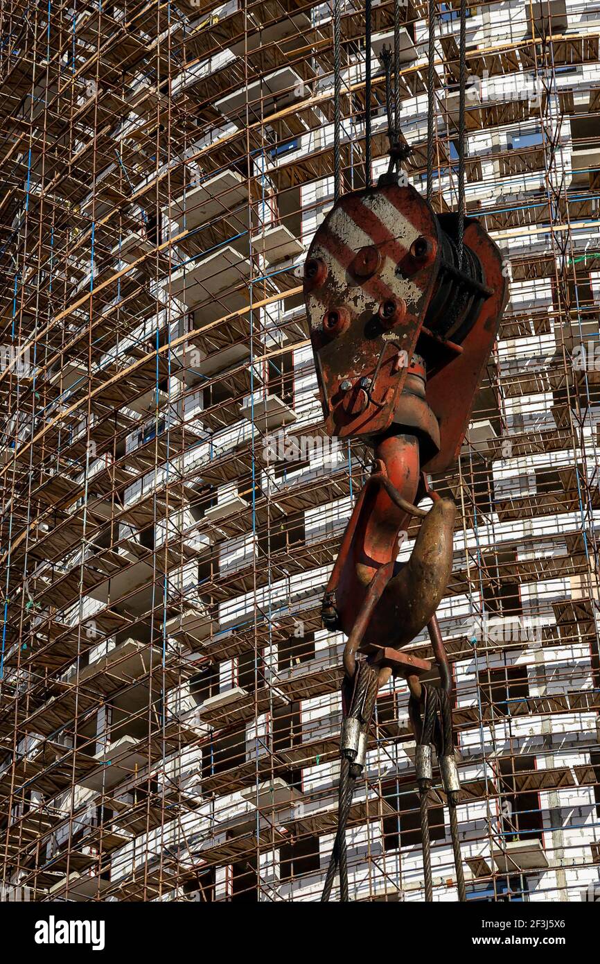 Construction crane hook with multi-storey building under construction ...