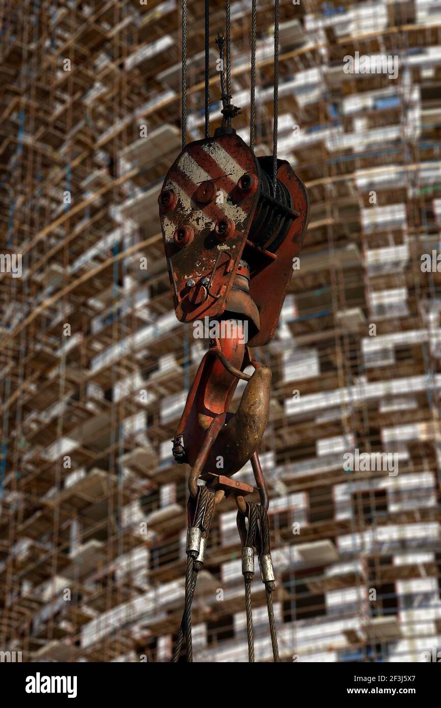 Construction crane hook with multi-storey building under construction ...