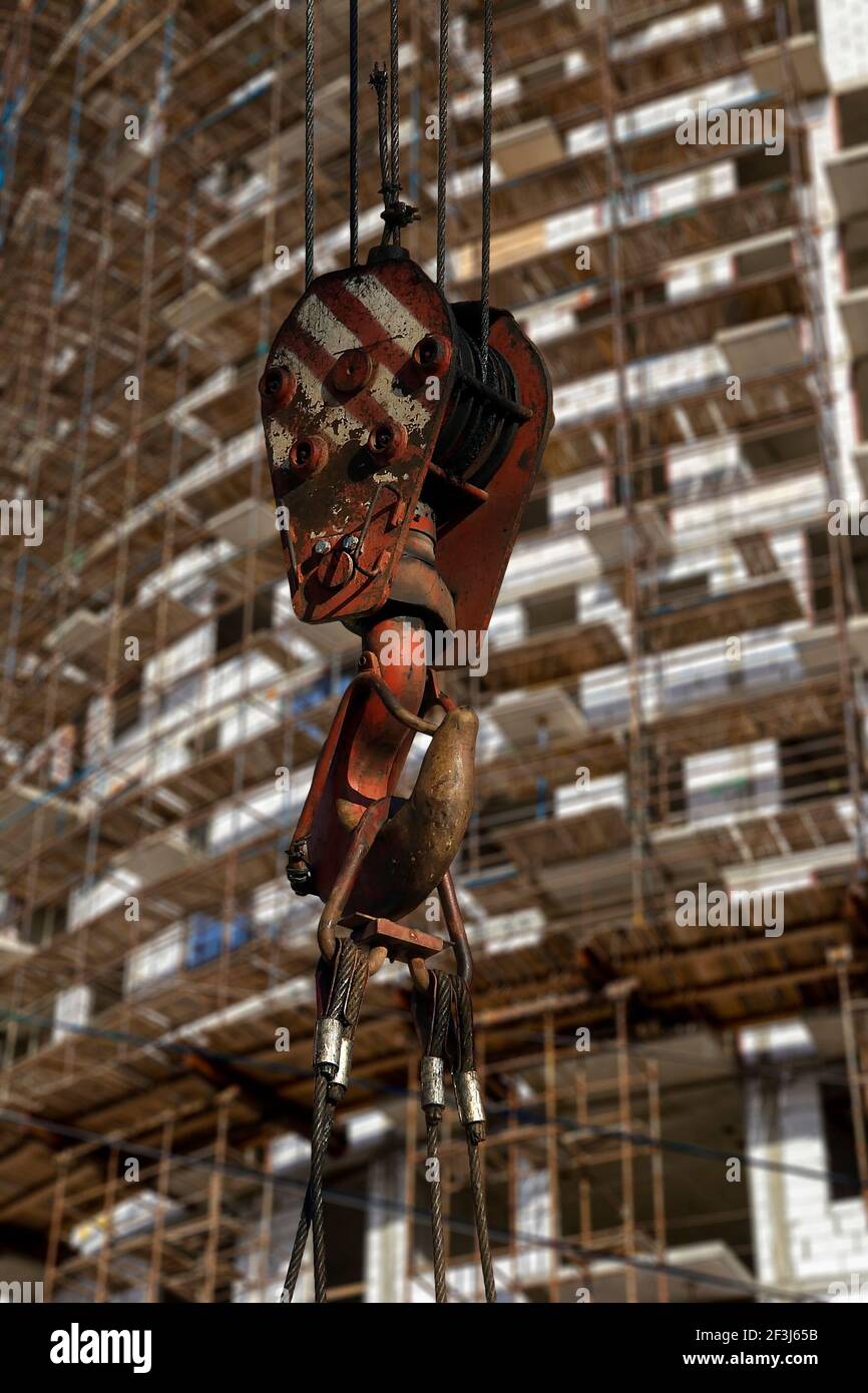 Construction crane hook with multi-storey building under construction ...