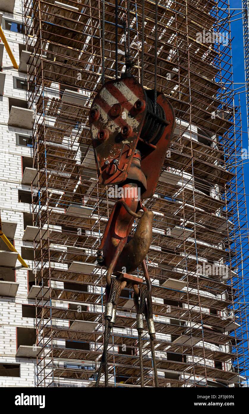 Construction crane hook with multi-storey building under construction ...