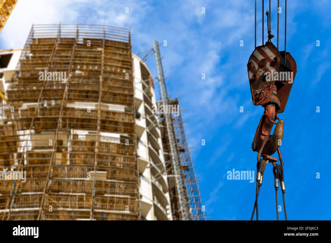 Construction crane hook with multi-storey building under construction ...
