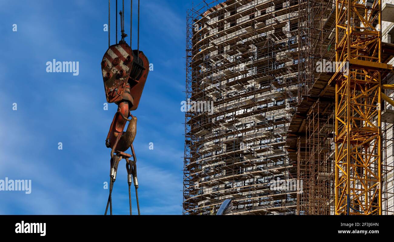 Construction crane hook with multi-storey building under construction ...