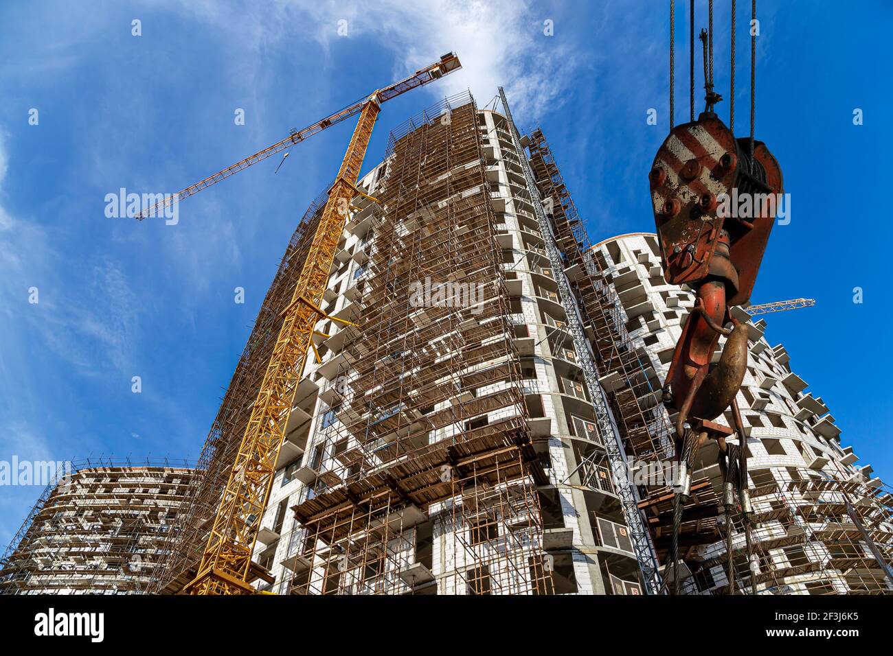 Construction crane hook with multi-storey building under construction ...