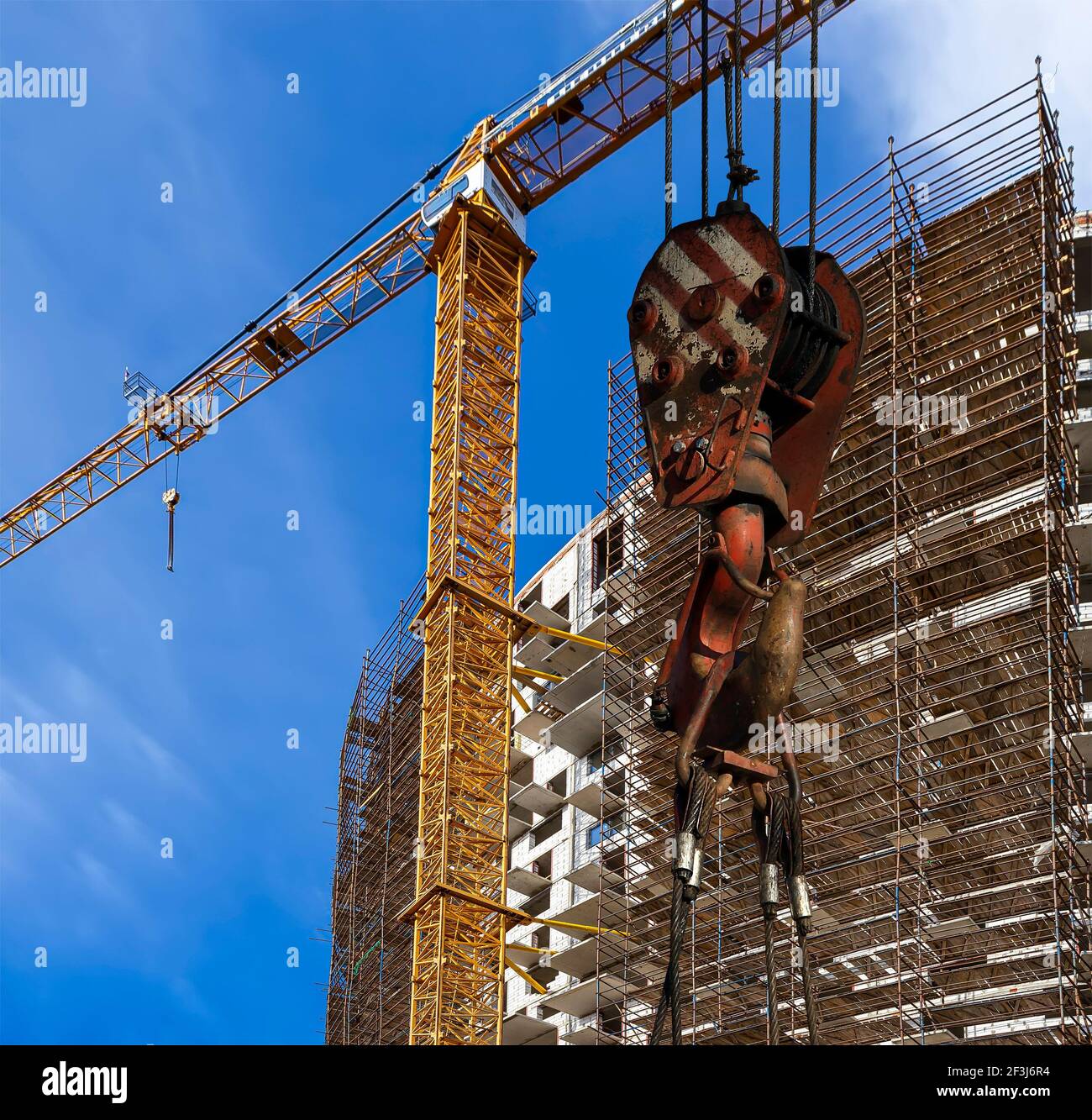 Construction crane hook with multi-storey building under construction ...