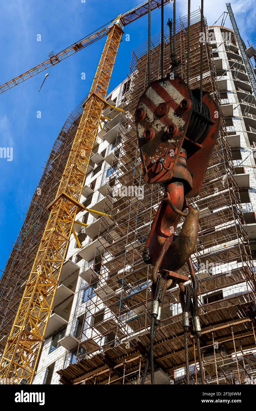 Construction crane hook with multi-storey building under construction ...