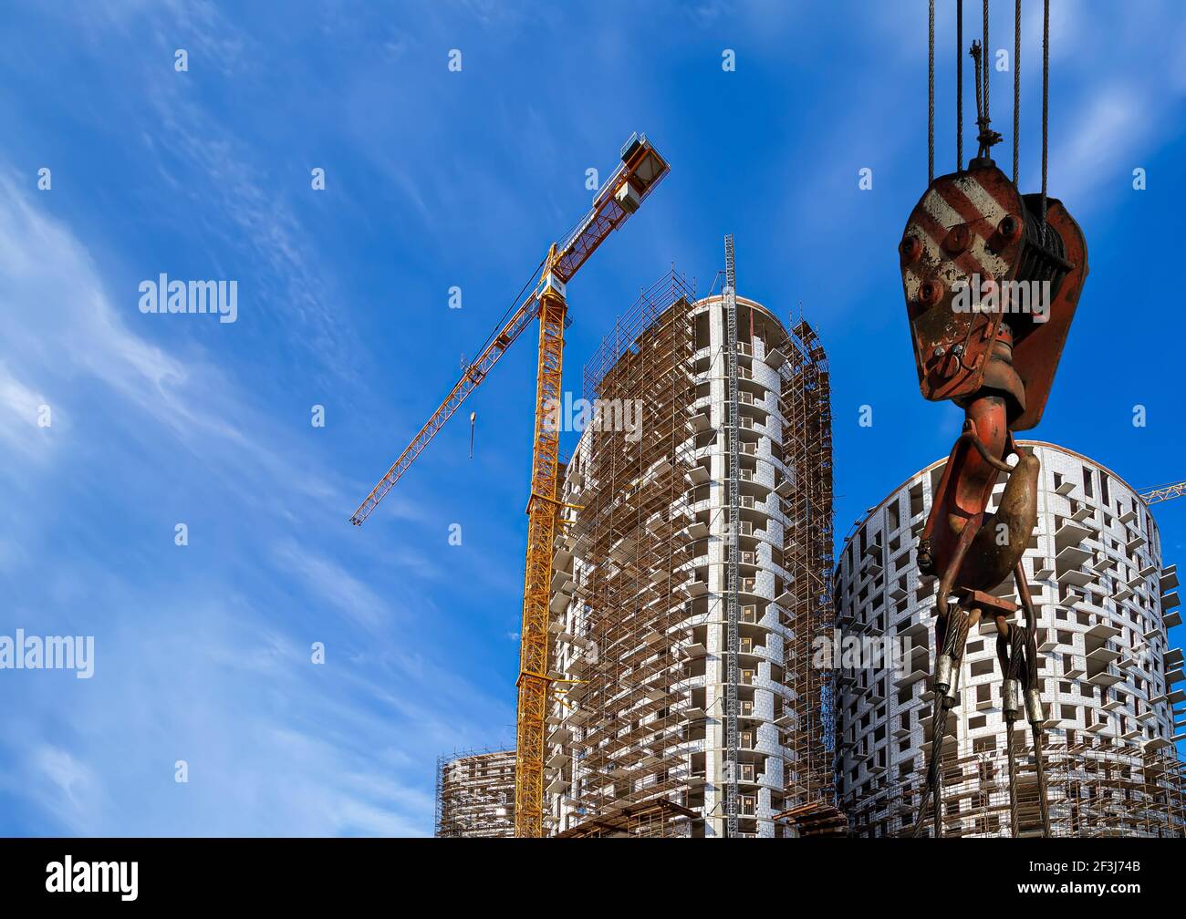 Construction crane hook with multi-storey building under construction ...