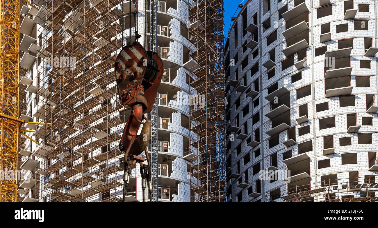Construction crane hook with multi-storey building under construction ...