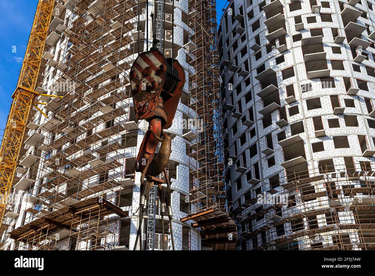 Construction crane hook with multi-storey building under construction ...