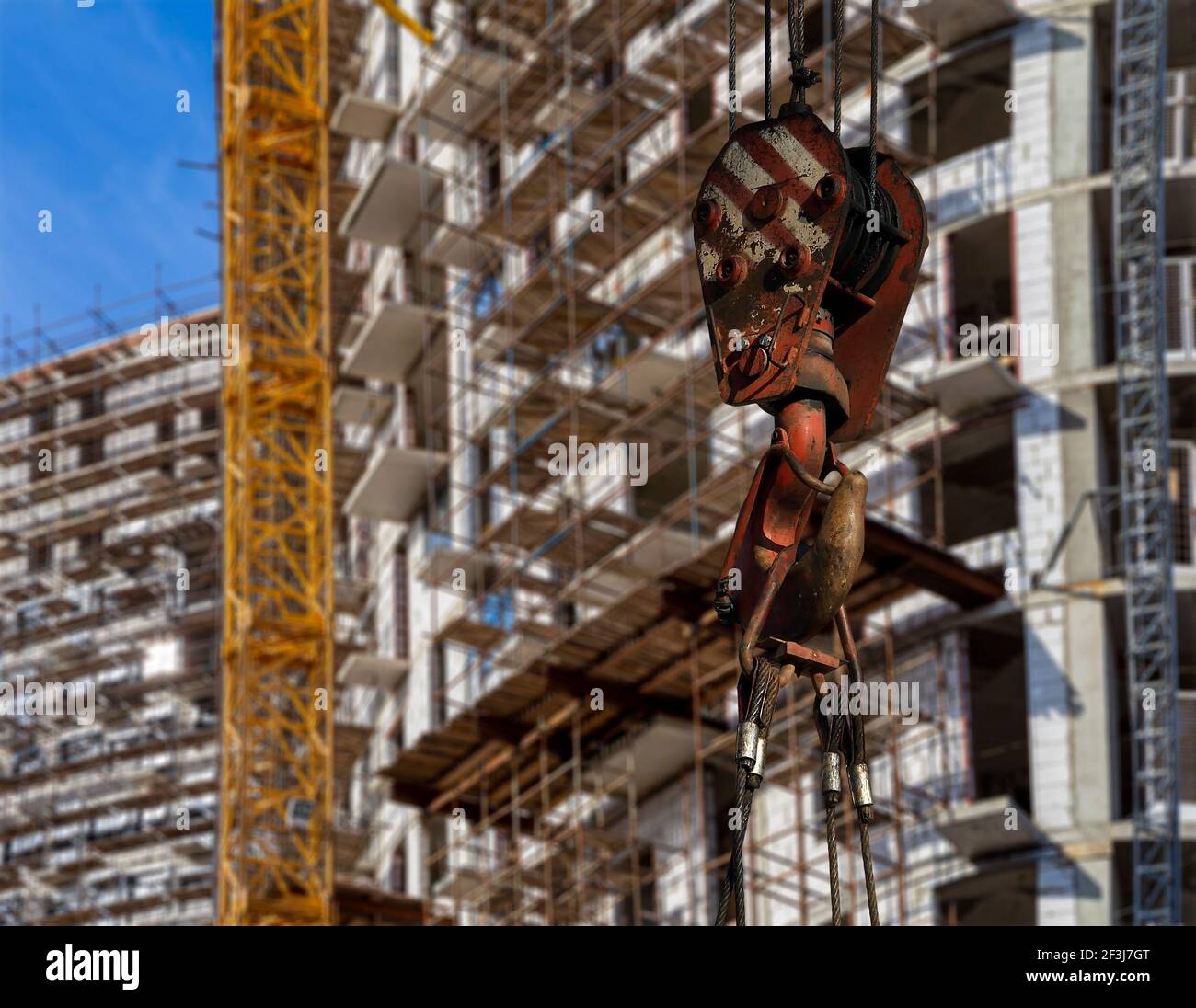 Construction crane hook with multi-storey building under construction ...
