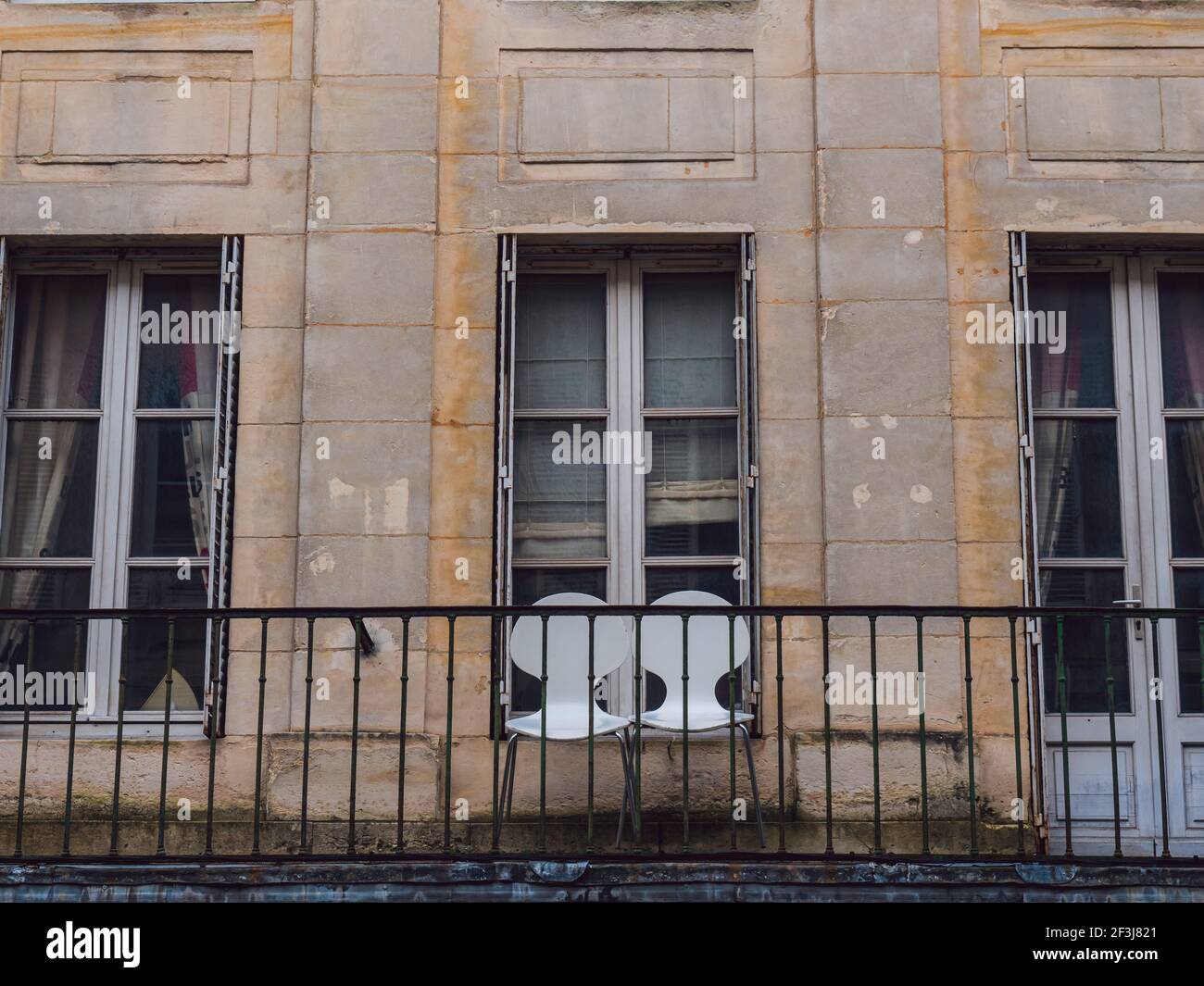 Two white chairs on the balcony in an old tenement house, a symbol of ...