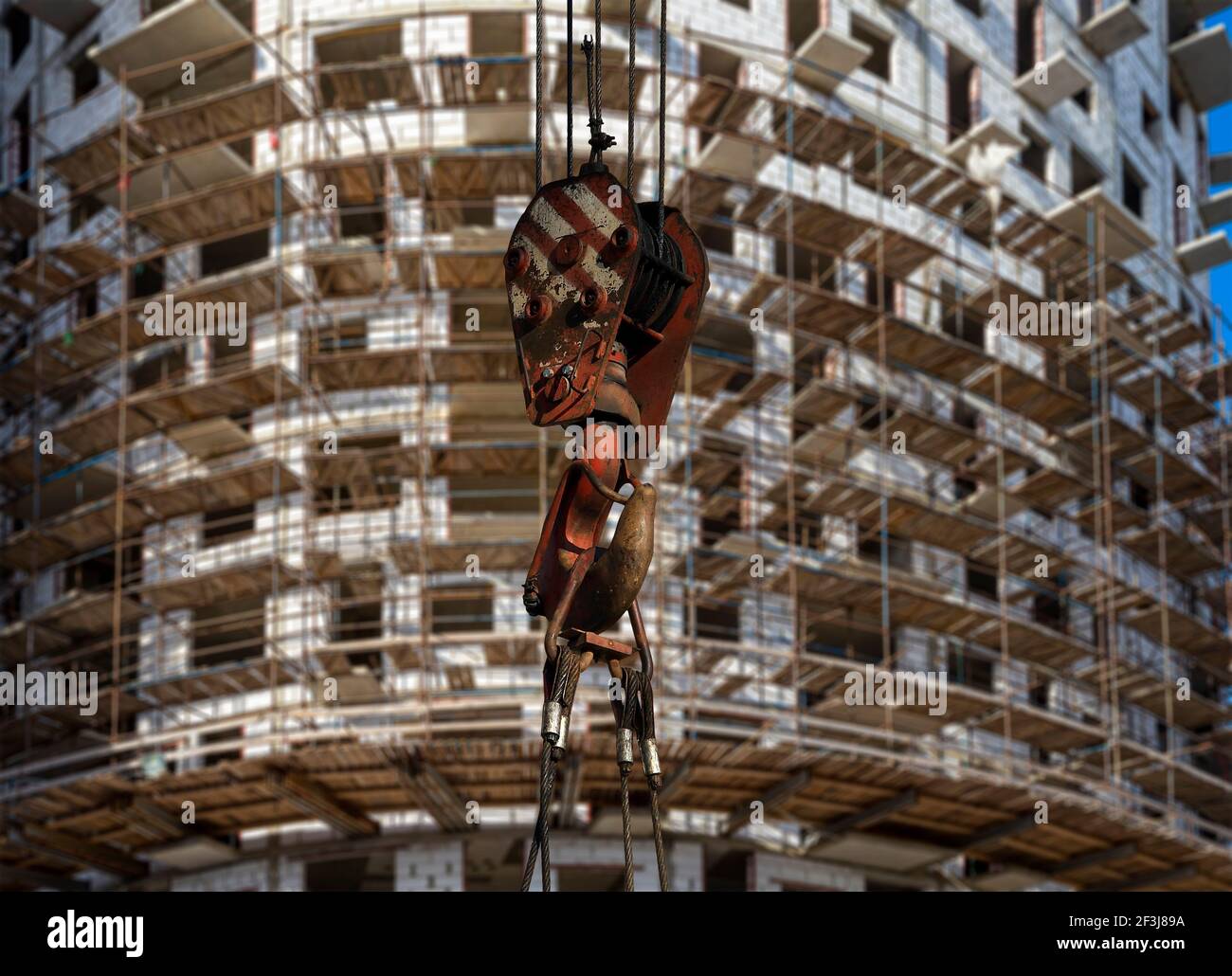 Construction crane hook with multi-storey building under construction ...