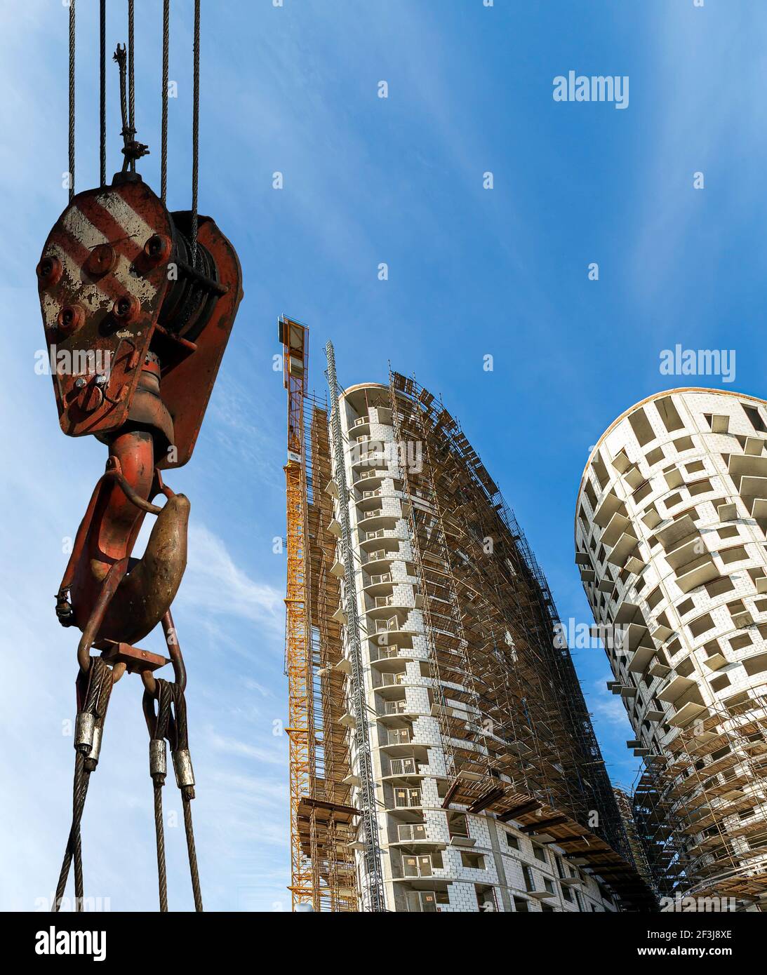 Construction crane hook with multi-storey building under construction ...