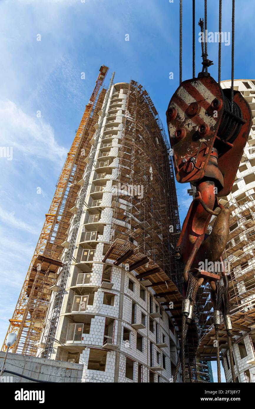 Construction crane hook with multi-storey building under construction ...