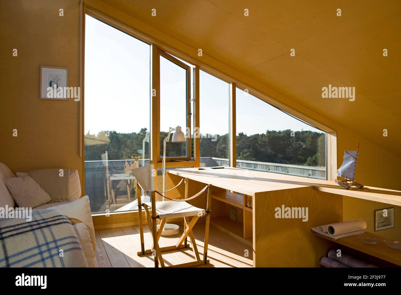 The first floor, a narrow open room with a desk and sofa Stock Photo ...