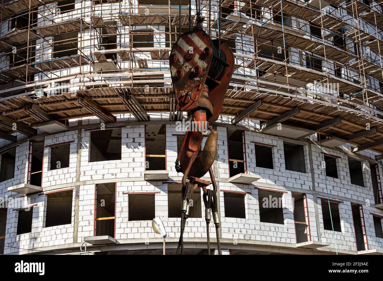 Construction crane hook with multi-storey building under construction ...