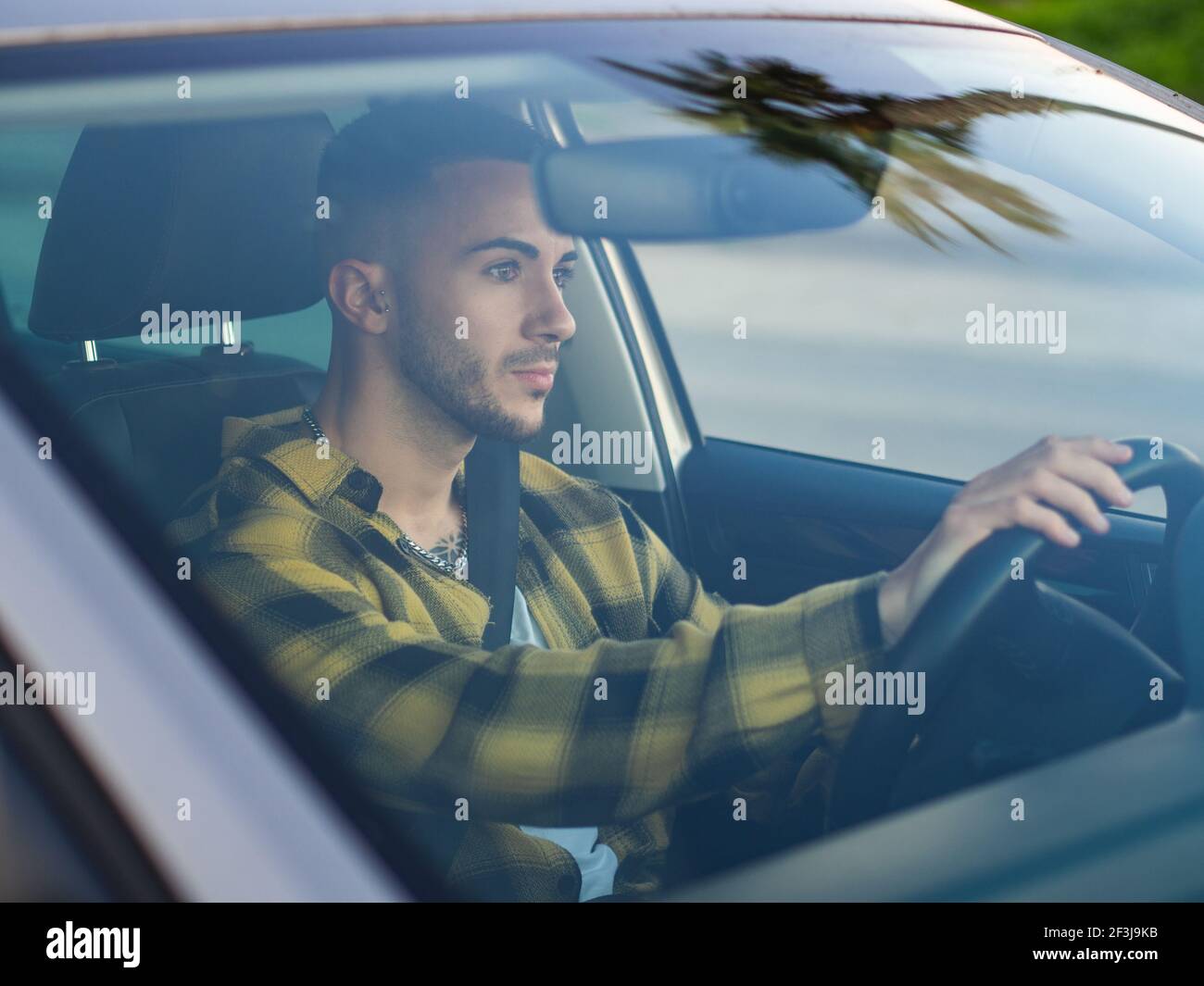A young Spanish man driving a car Stock Photo - Alamy