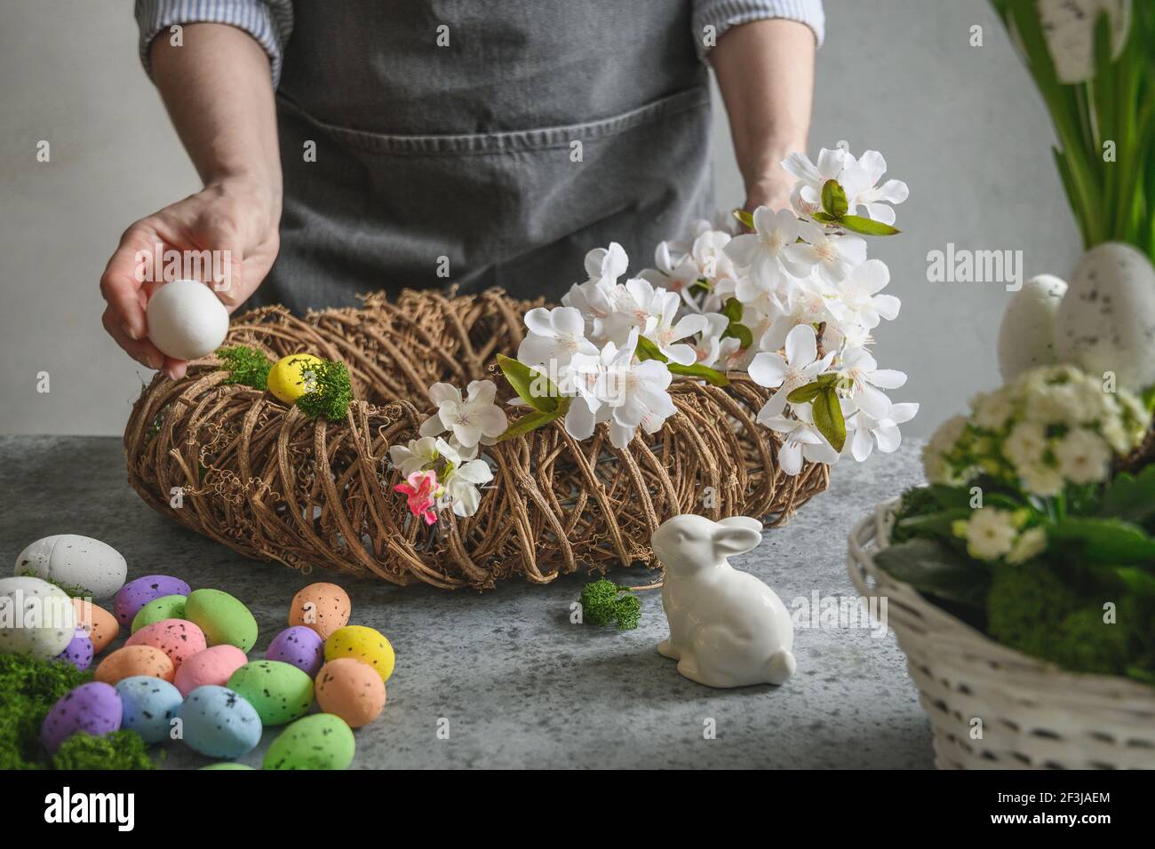 Woman making Easter floral wreath of natural materials, blossom flowers ...