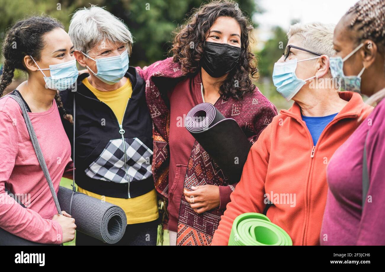 Multi generational women having fun before yoga class wearing safety ...