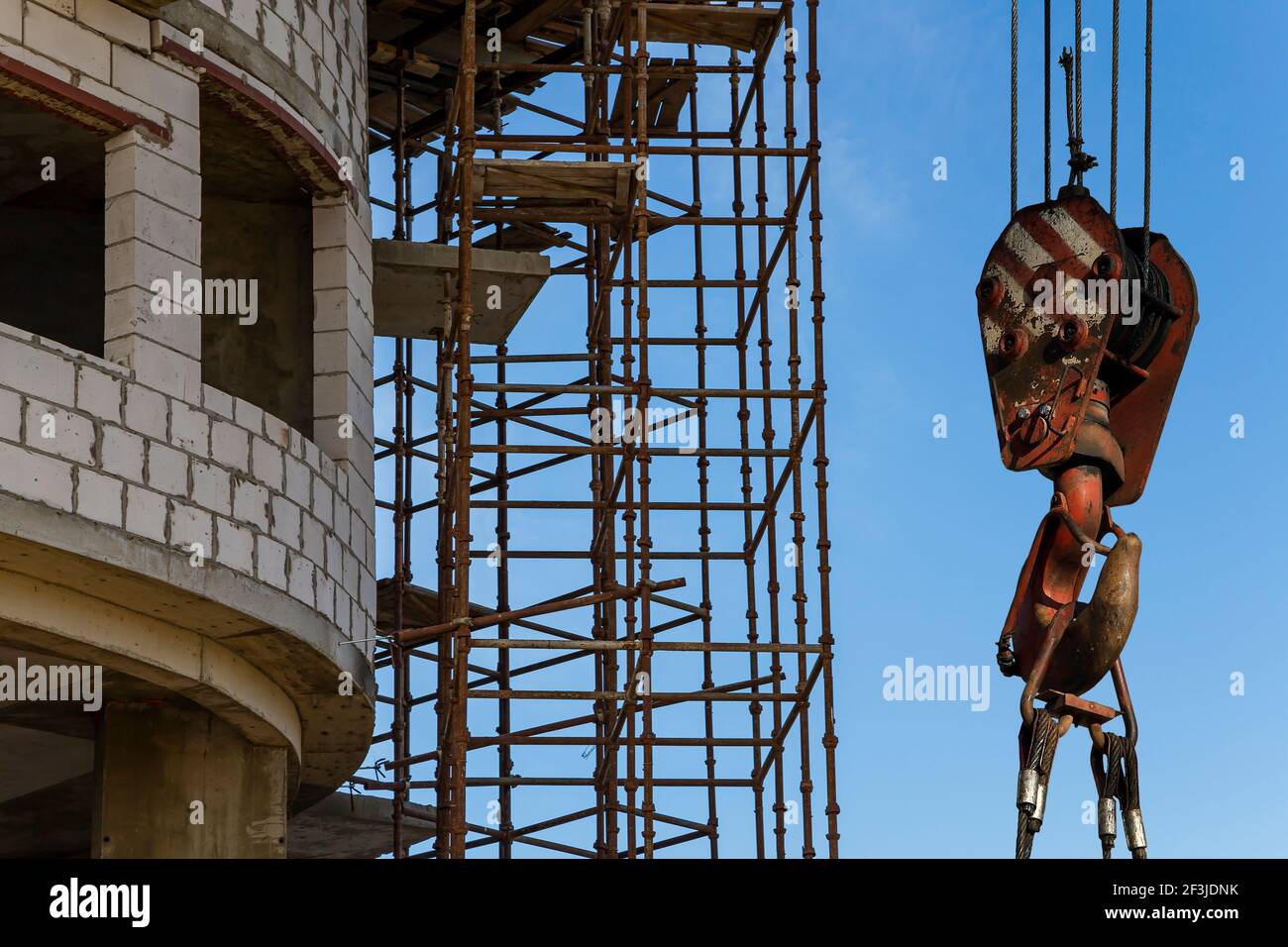 Construction crane hook with multi-storey building under construction ...