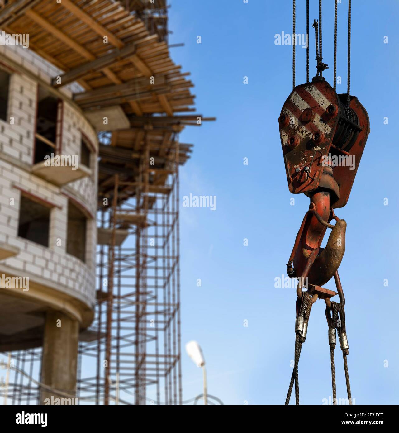 Construction crane hook with multi-storey building under construction ...