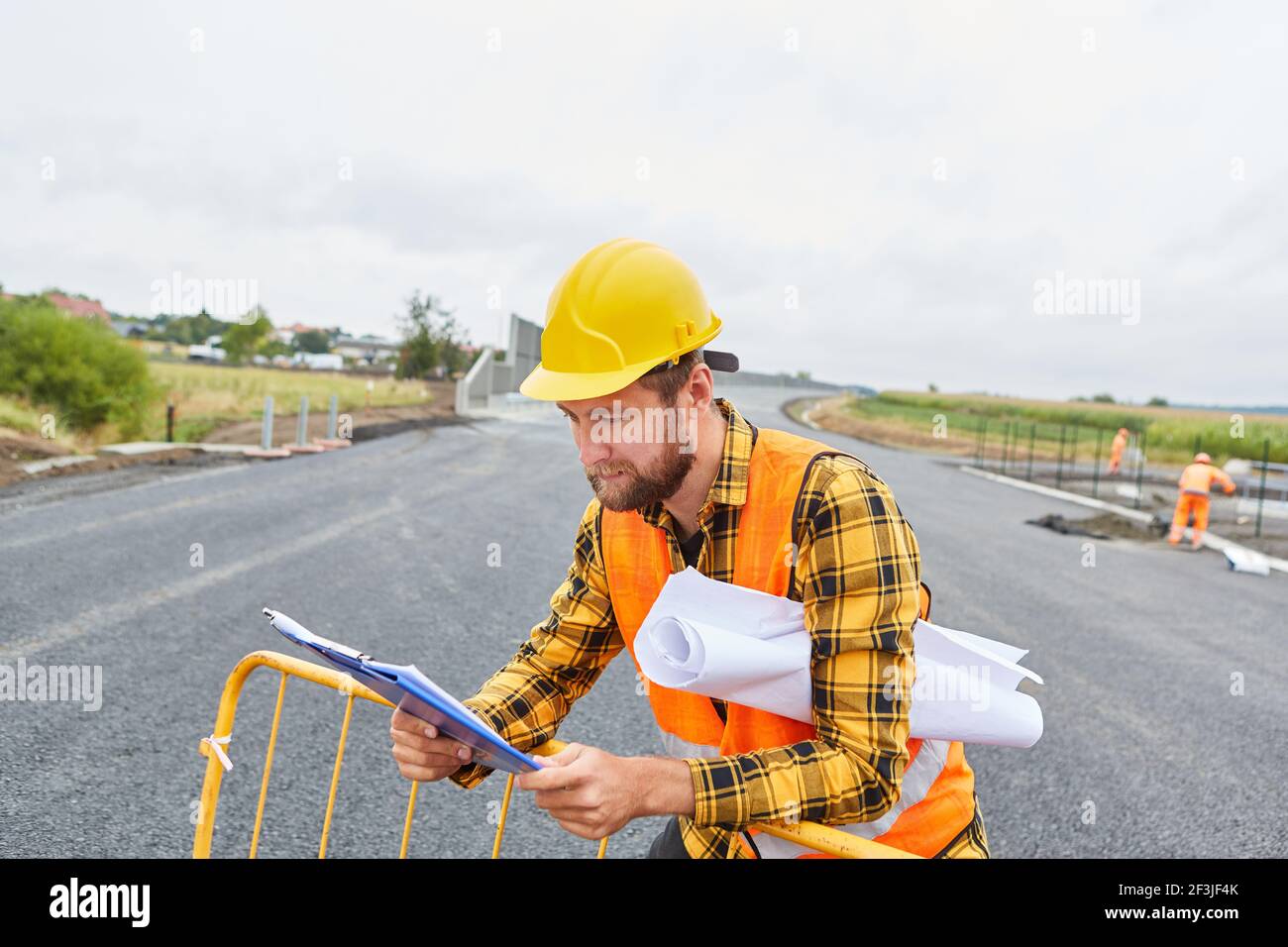 Worker on the construction site of road construction with checklist and ...