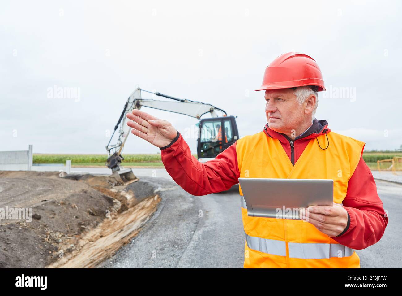 Construction worker as site manager with tablet computer during ...